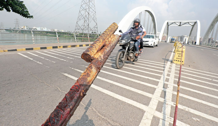 A broken iron rod of the makeshift road divider has moved aside, posing ...